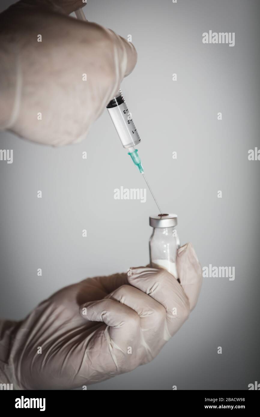 Vertical shot of the doctor holding vaccine - the concept of a cure for ...