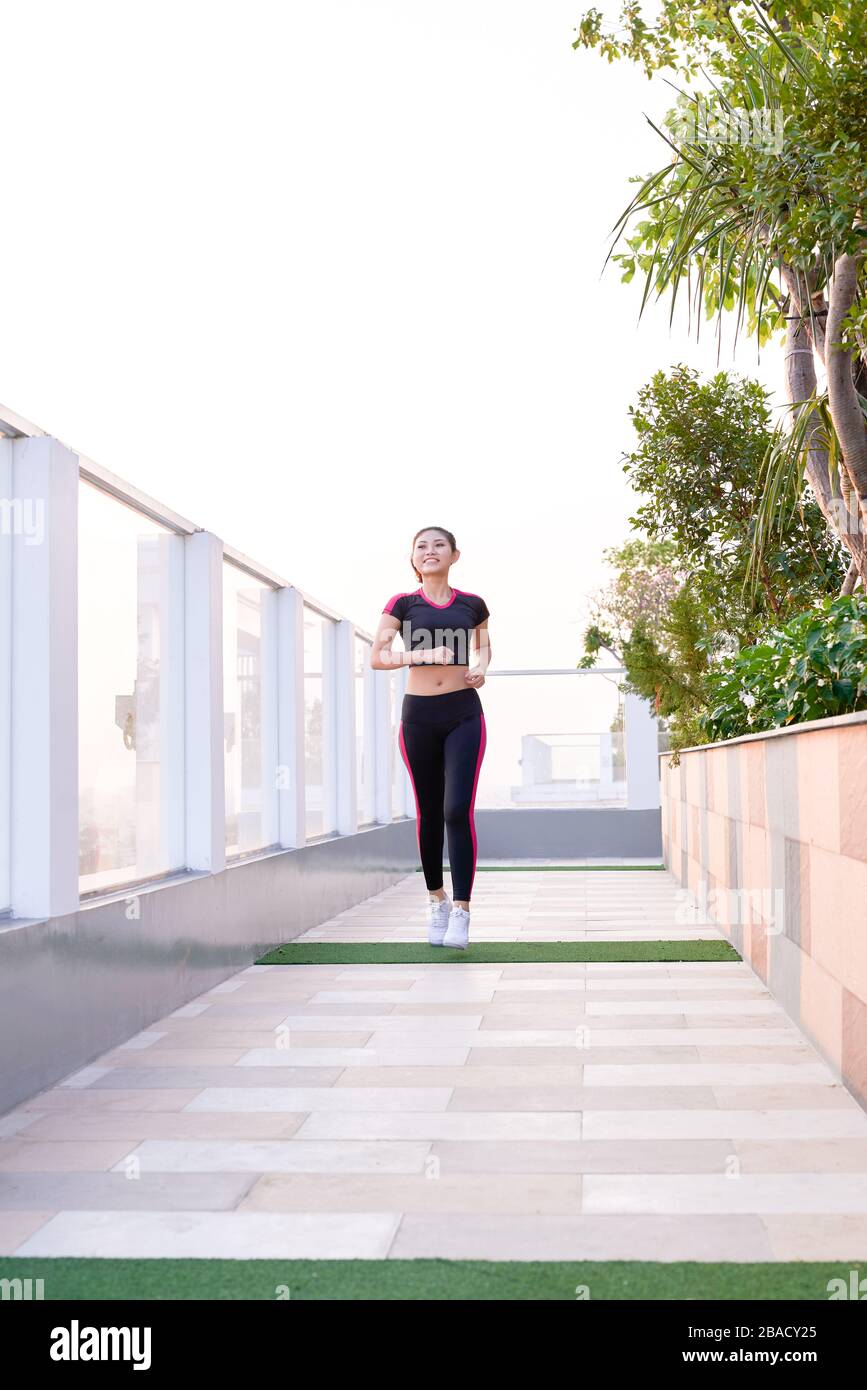 Fitness woman she is running the road Stock Photo - Alamy