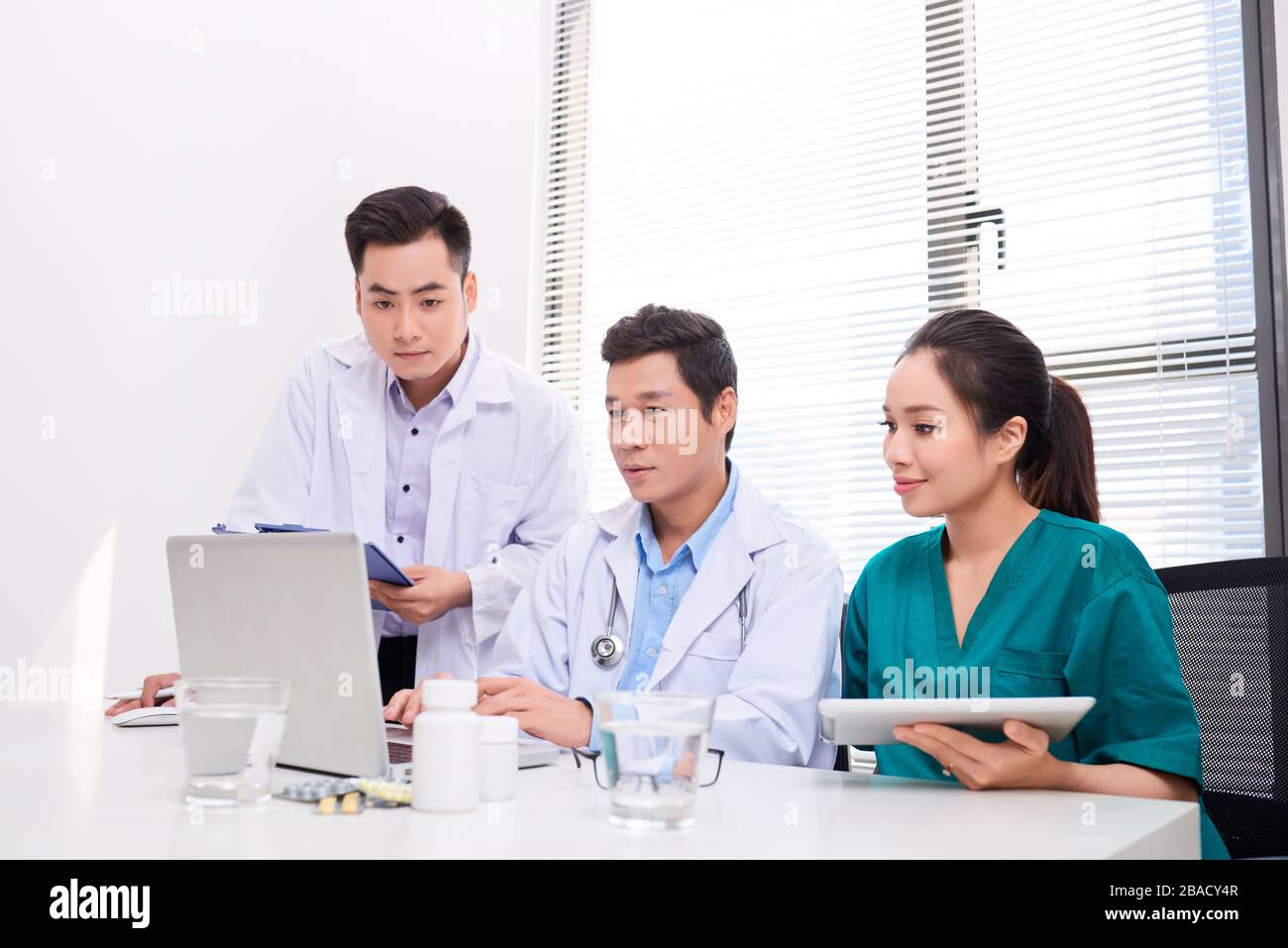 Doctor team working at computer desk in hospital Stock Photo - Alamy