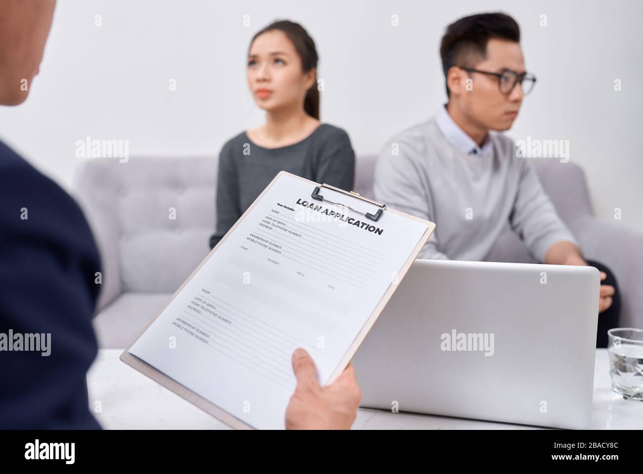 Young angry couple of cheated investors holding papers arguing with ...