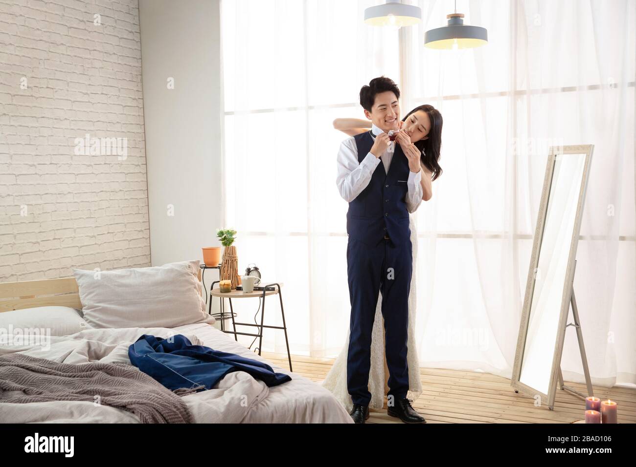 Young wife help her husband to the tie Stock Photo - Alamy