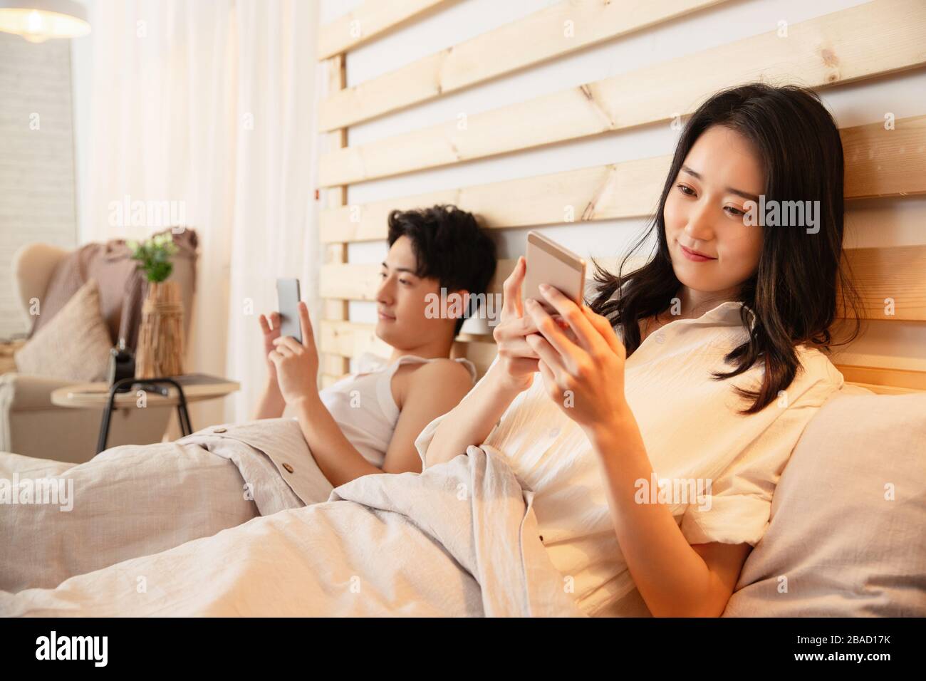 Young lovers in bed using a cell phone Stock Photo - Alamy