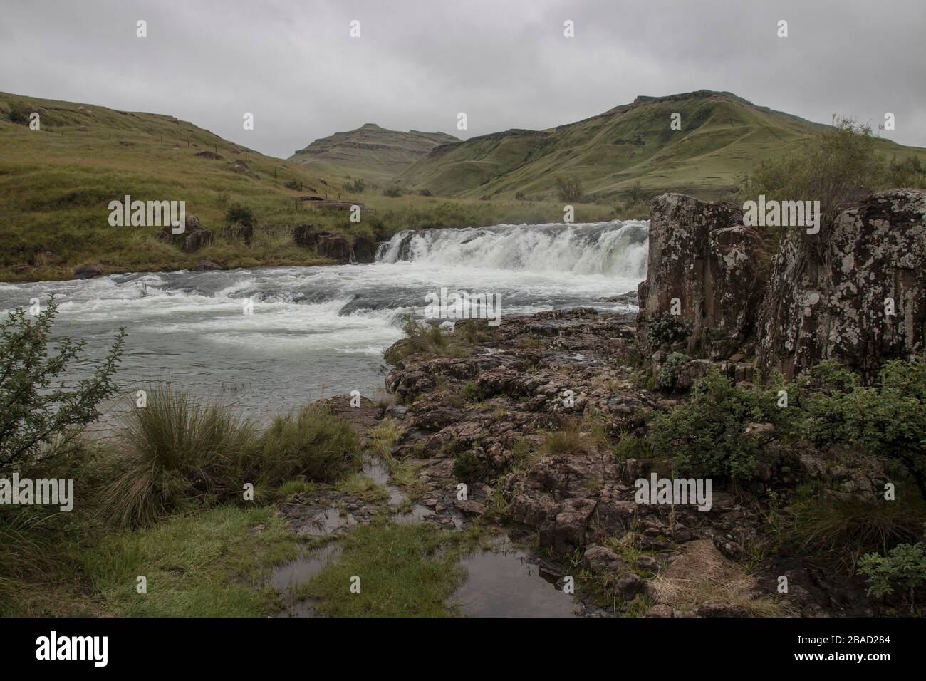 Water flowing fast over rapids of flooding river Stock Photo - Alamy