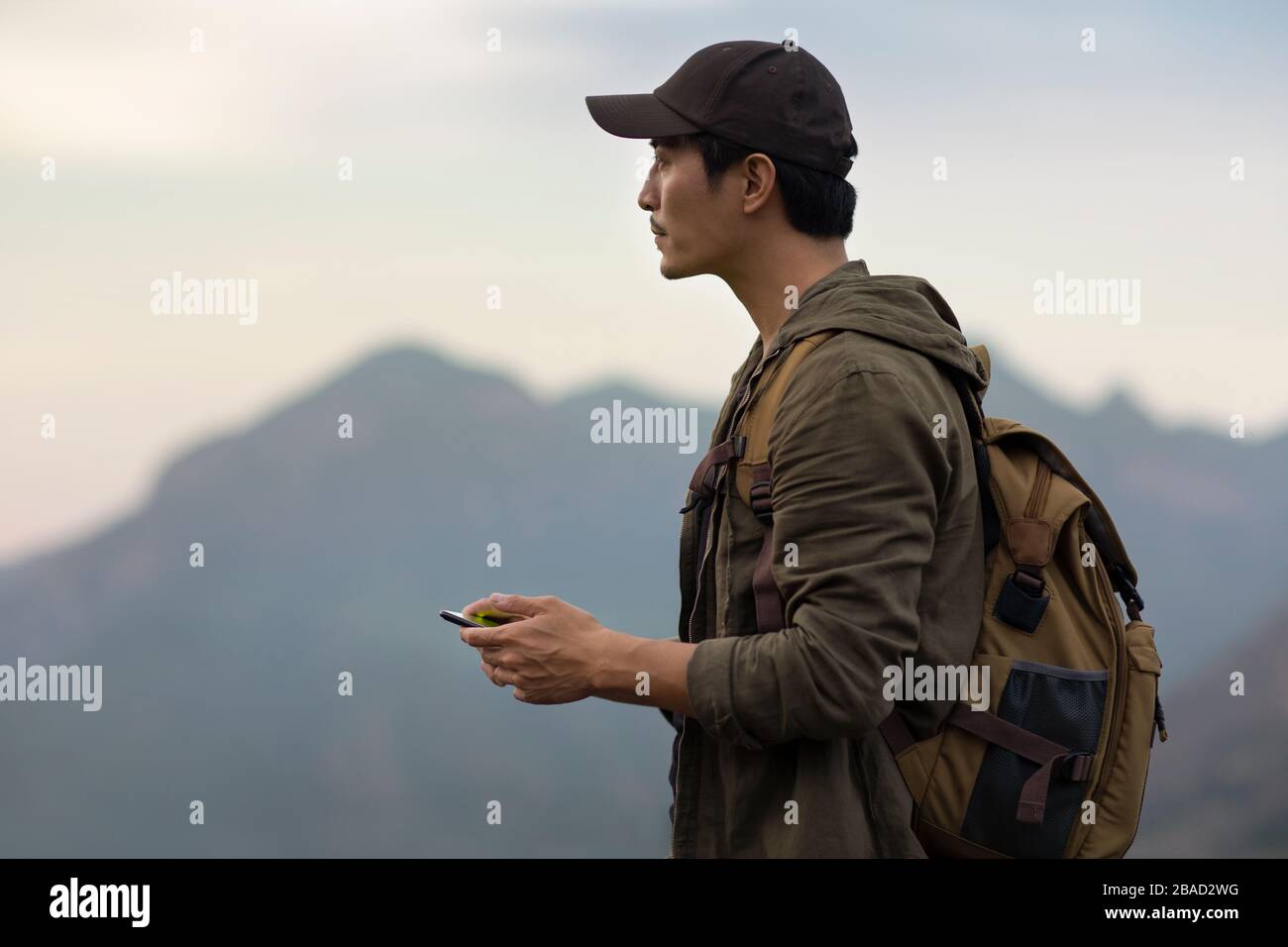Young Chinese man using smartphone outdoors Stock Photo - Alamy