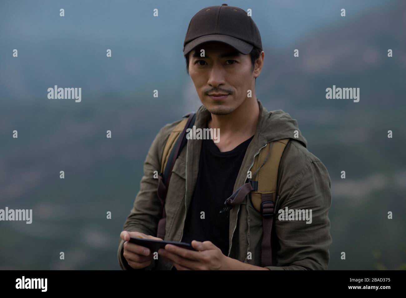 Young Chinese man using smartphone outdoors Stock Photo - Alamy