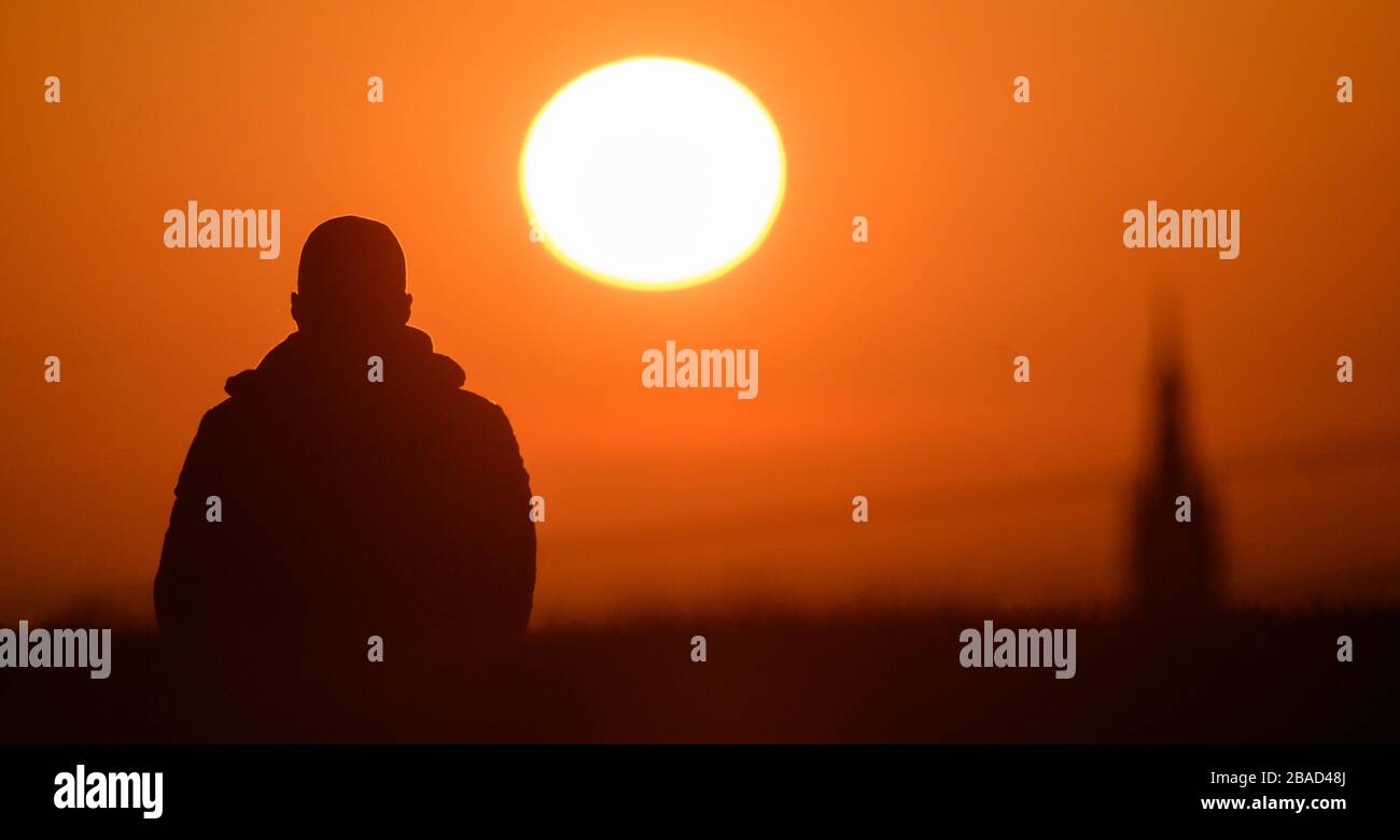 Leinfelden Echterdingen, Germany. 27th Mar, 2020. A man watches the ...