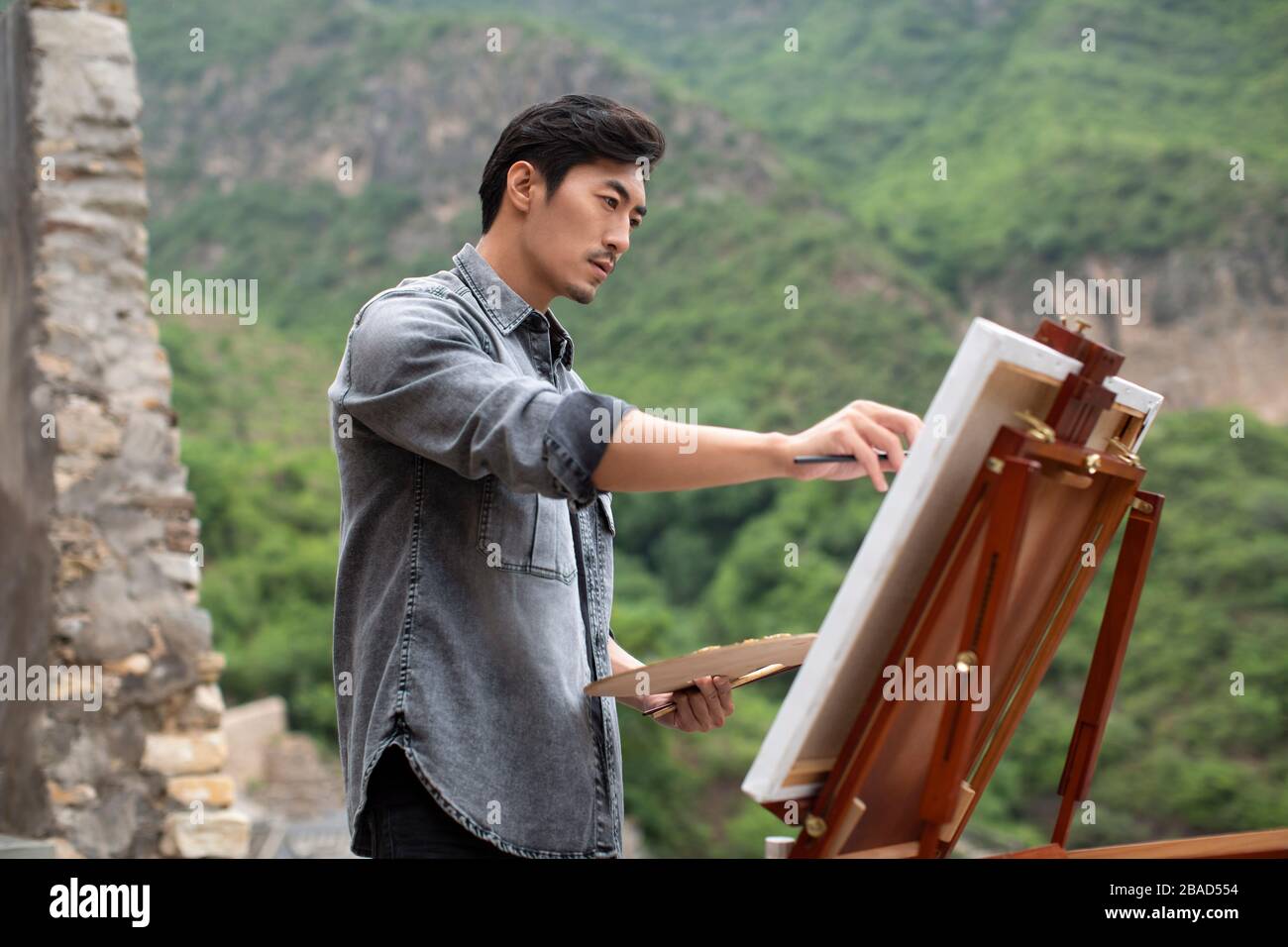 Young Chinese artist painting outdoors Stock Photo - Alamy