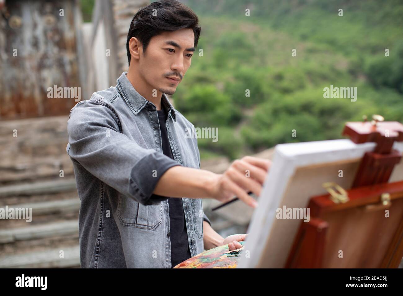 Young Chinese artist painting outdoors Stock Photo - Alamy