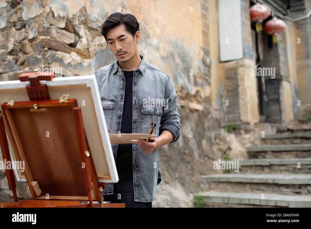 Young Chinese artist painting outdoors Stock Photo - Alamy