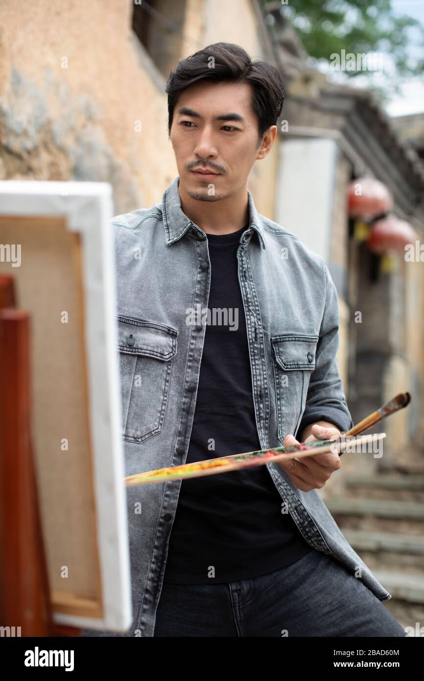 Young Chinese artist painting outdoors Stock Photo - Alamy