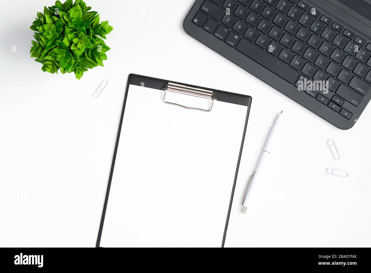 Home office workspace with laptop computer keyboard, blank paper ...