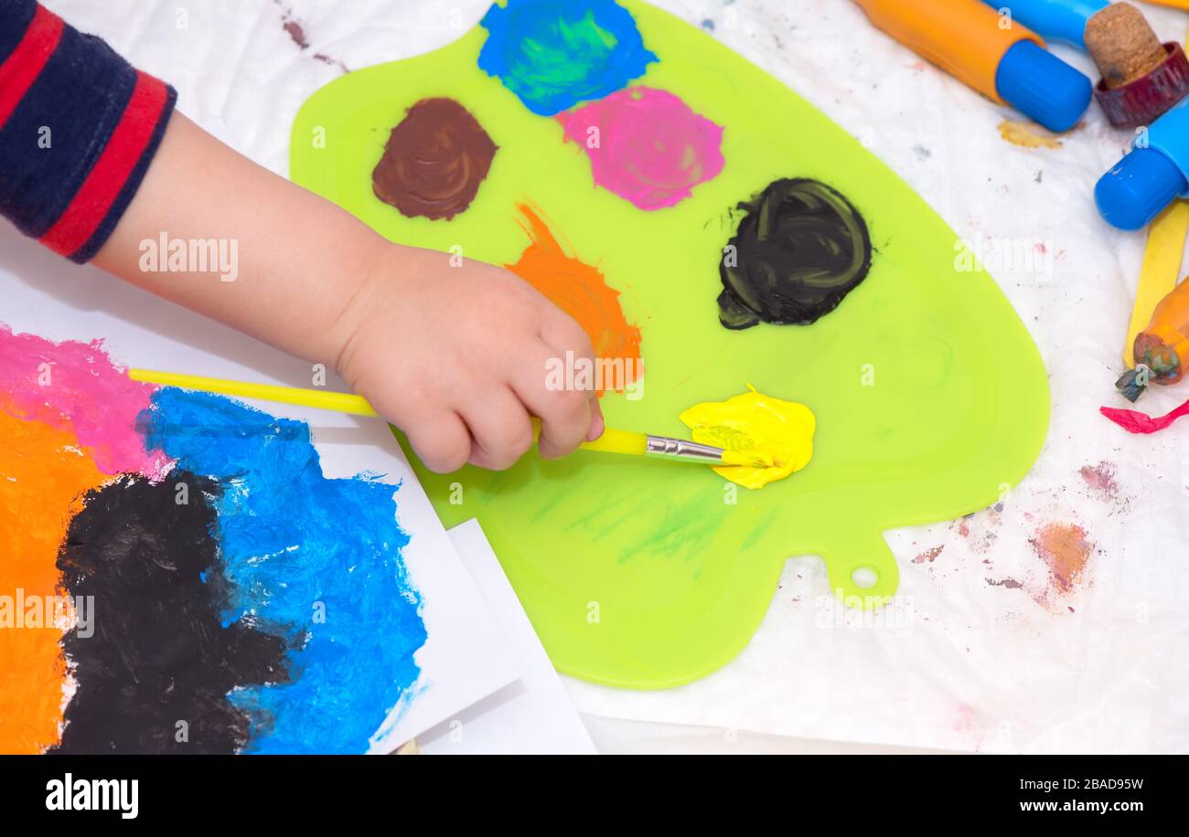 Hand of a little child holding a painting brush Stock Photo - Alamy