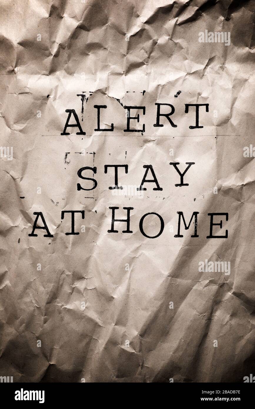 Alert Stay at Home text on a brown paper Stock Photo - Alamy