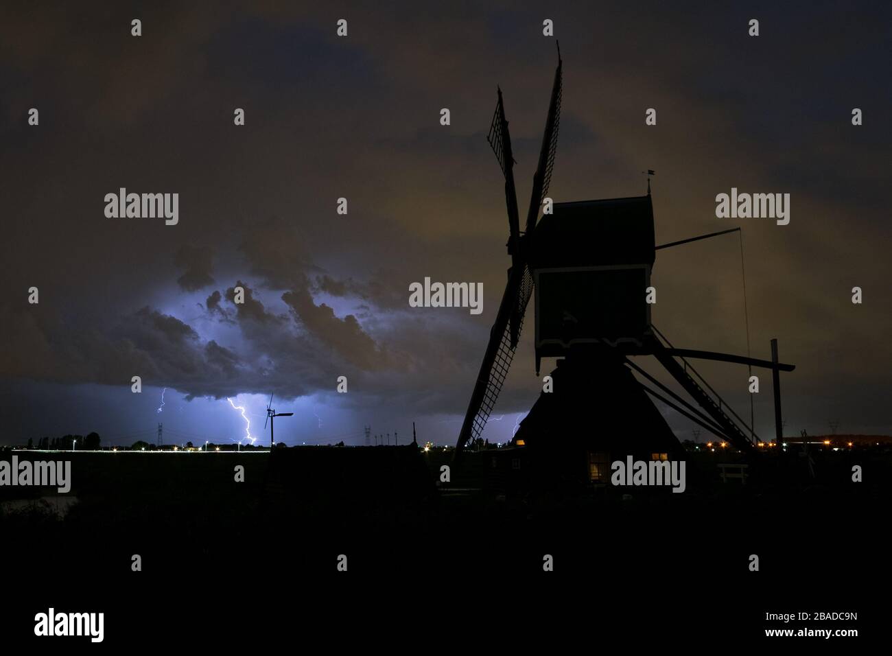 Windmill silhouette with lightning storm in the background Stock Photo ...