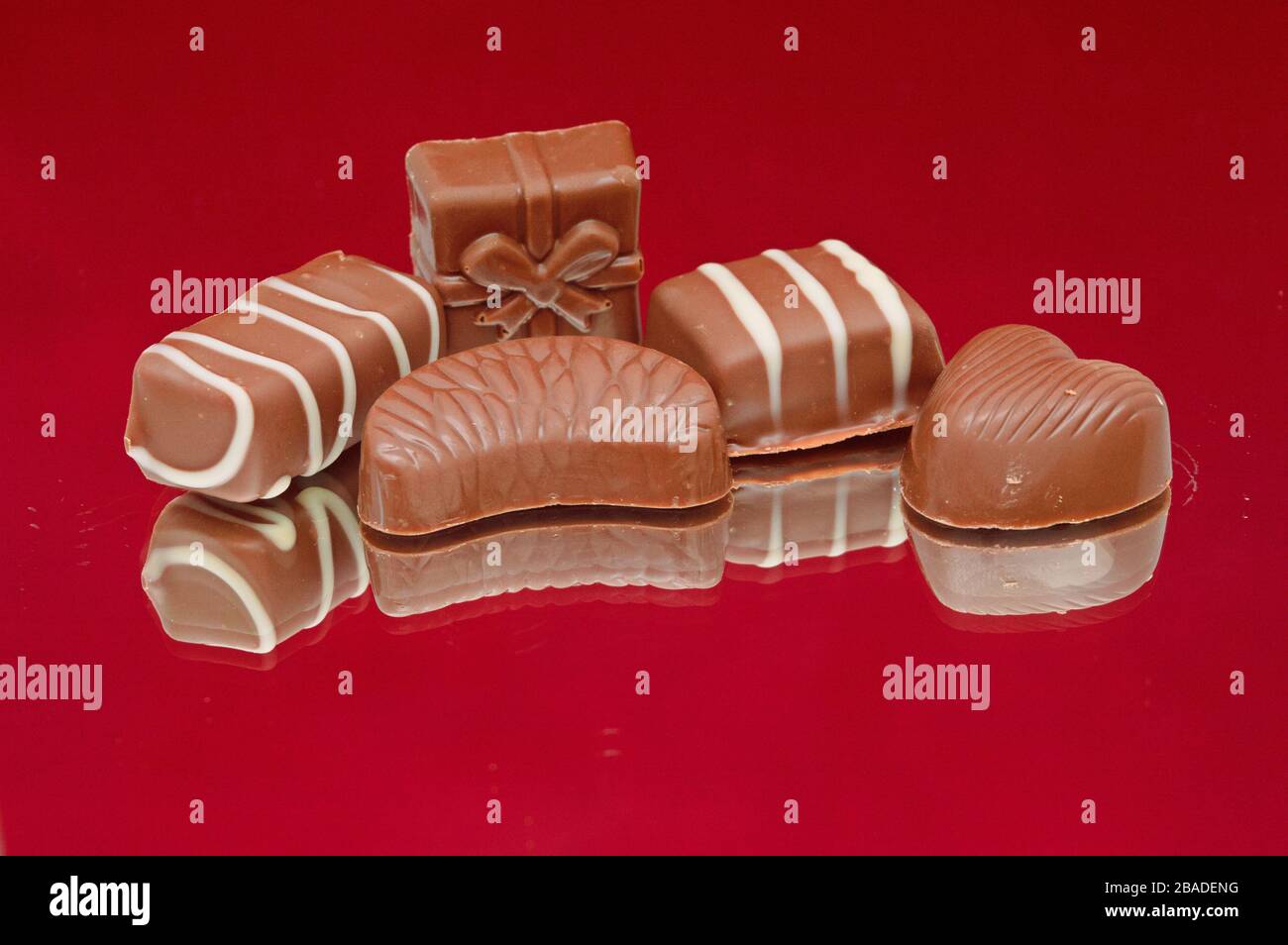 5 Chocolates with a red background Stock Photo - Alamy