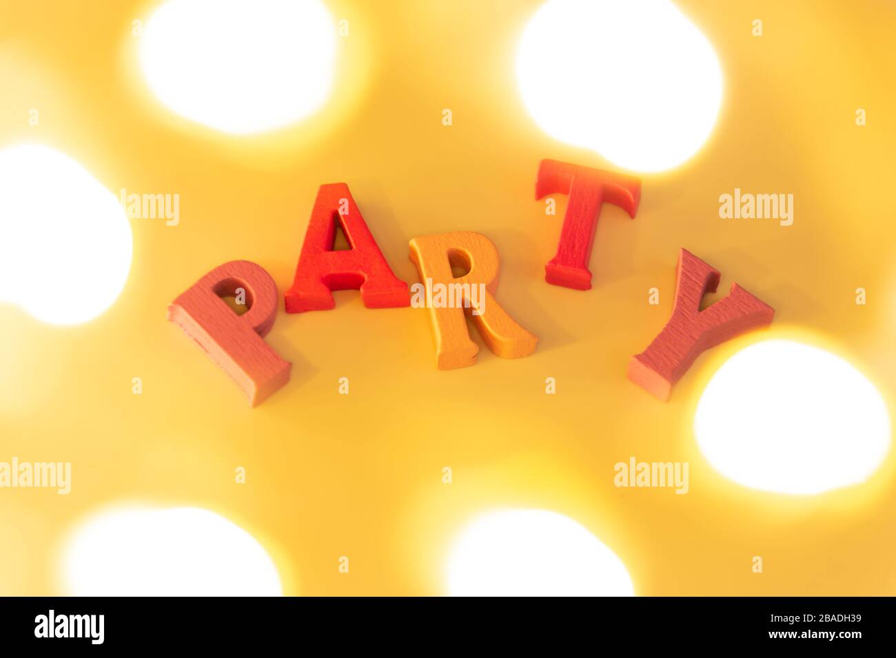The colorful word party on yellow background with defocused glowing ...