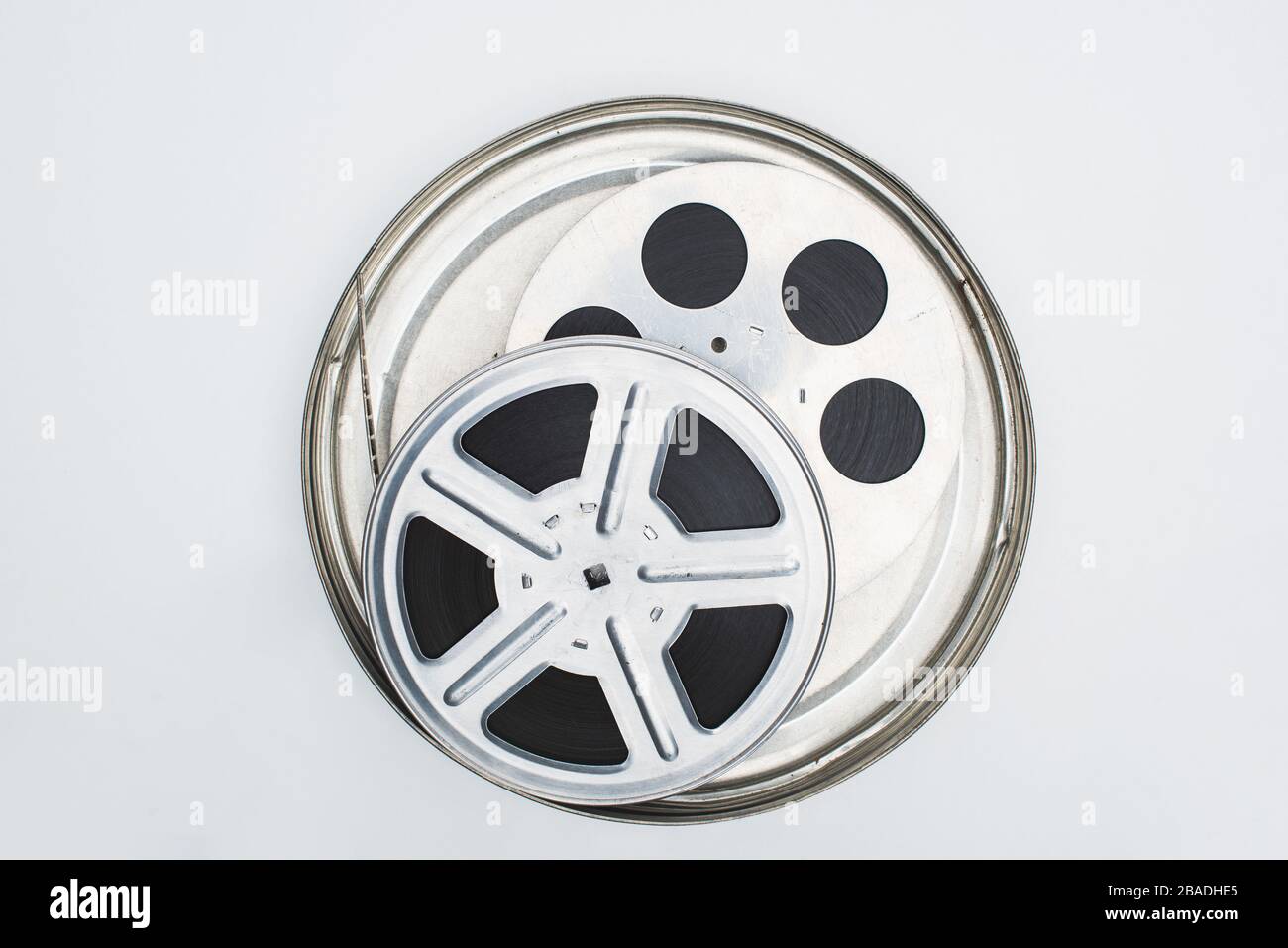 top view of film reels with film strip in tin case on white background ...