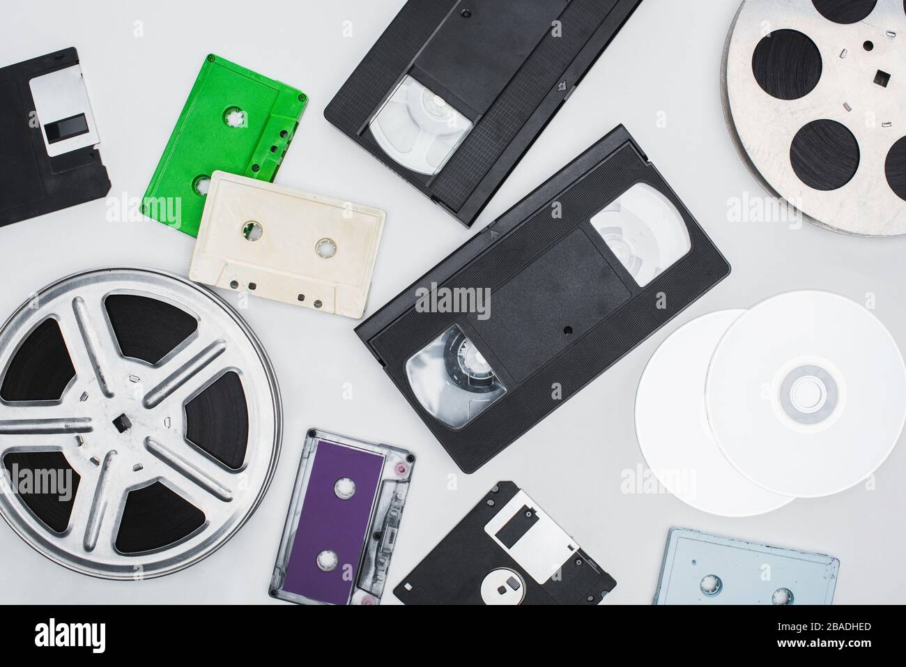 flat lay of VHS cassettes, diskettes, CD discs, film reels and colorful ...