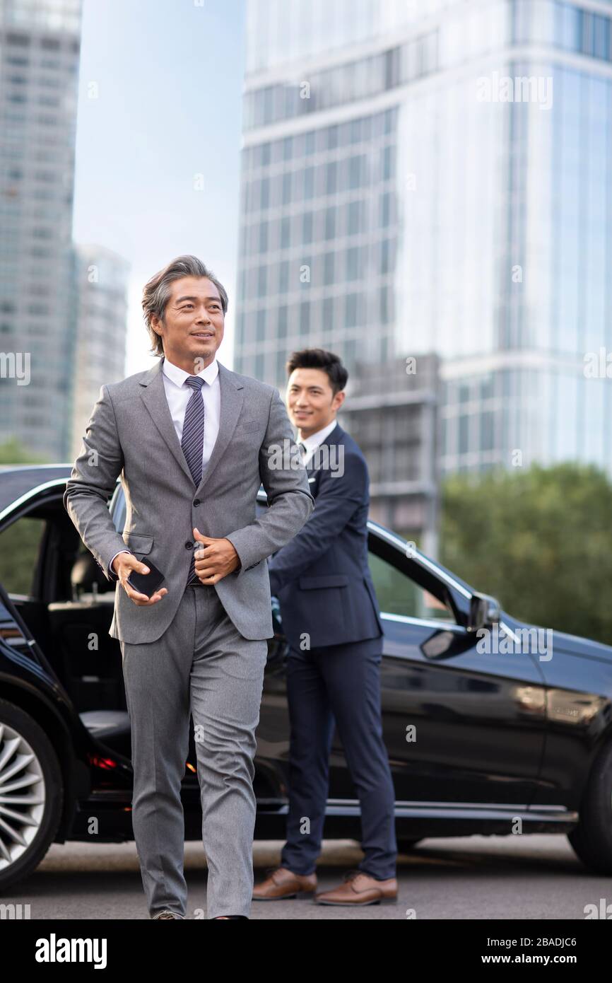 Confident Chinese businessman getting out of car Stock Photo - Alamy