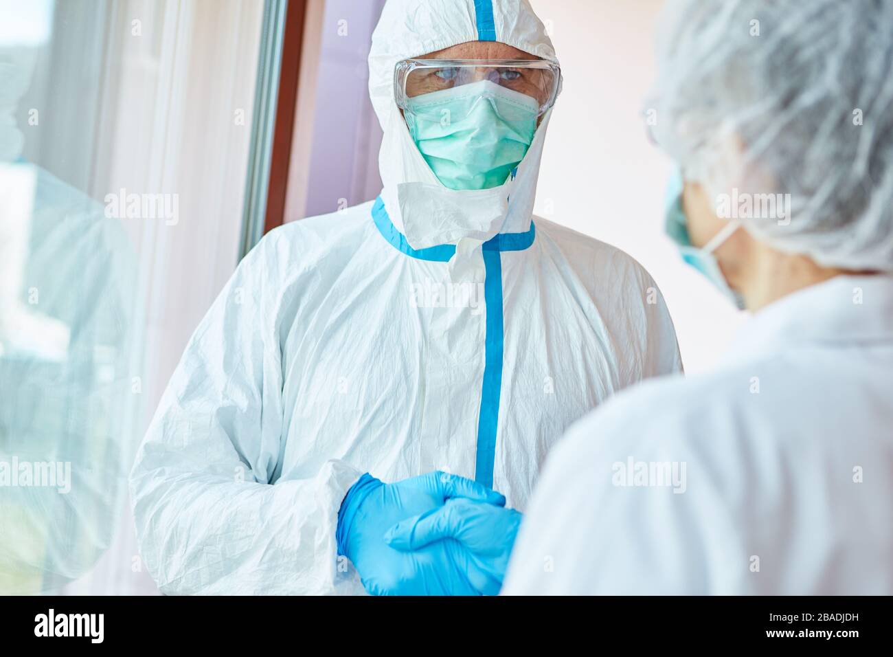 Doctors in protective clothing giving handshake in a clinic Stock Photo ...