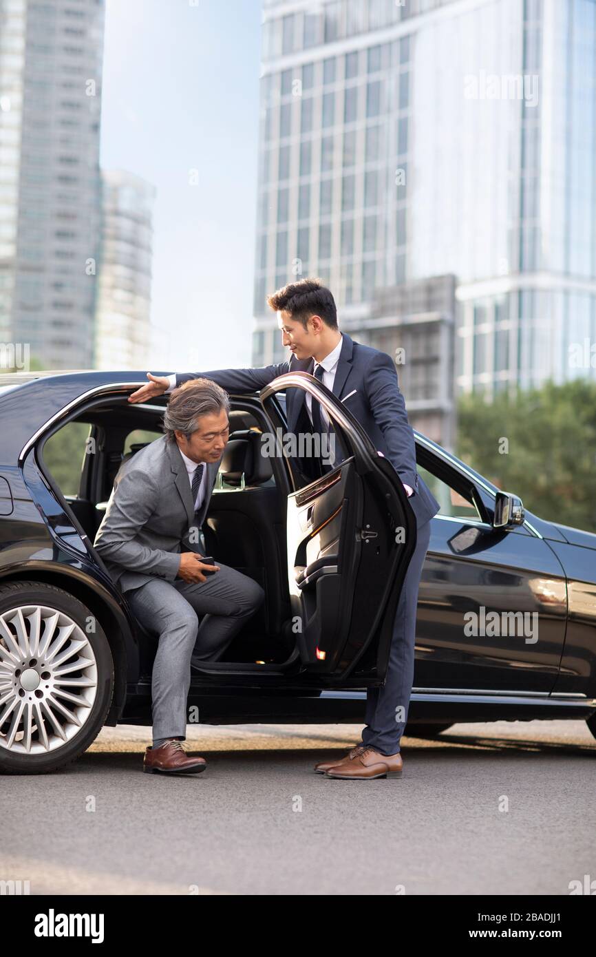 Confident Chinese businessman getting out of car Stock Photo - Alamy