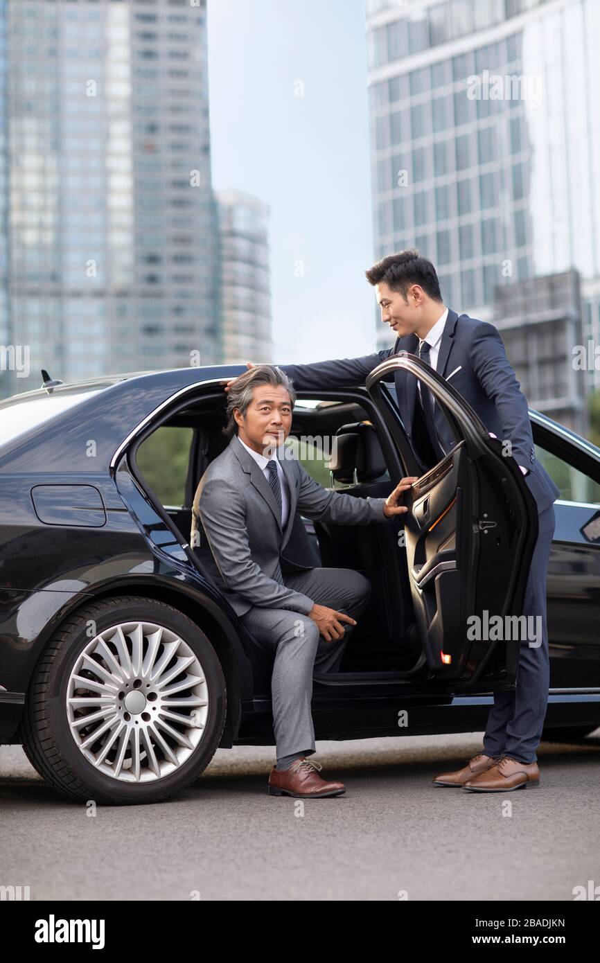 Confident Chinese businessman getting out of car Stock Photo - Alamy