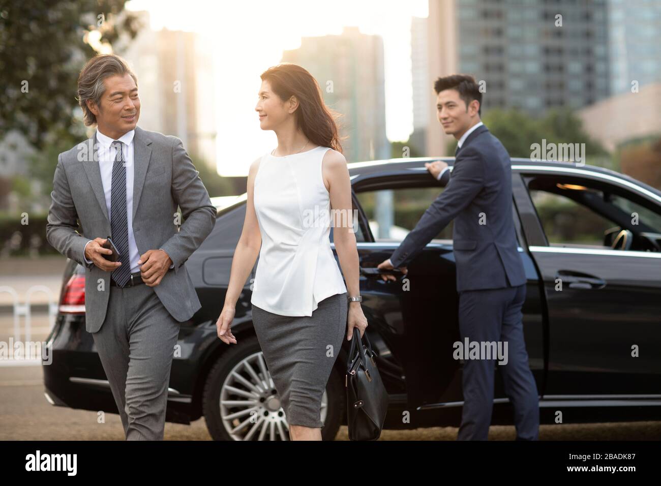 Confident Chinese business people getting out of car Stock Photo - Alamy