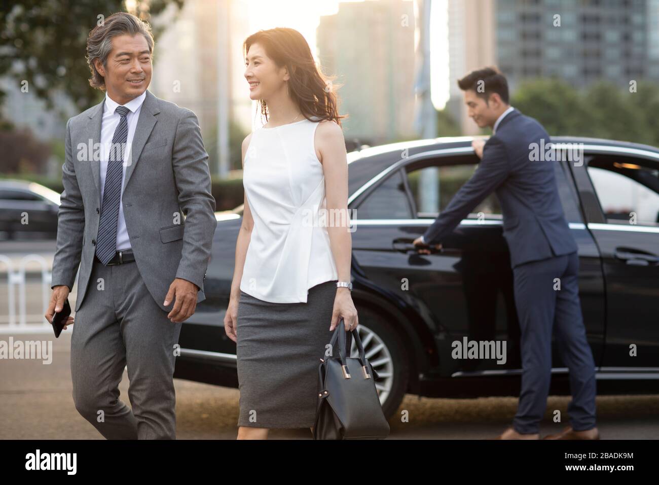 Confident Chinese business people getting out of car Stock Photo - Alamy