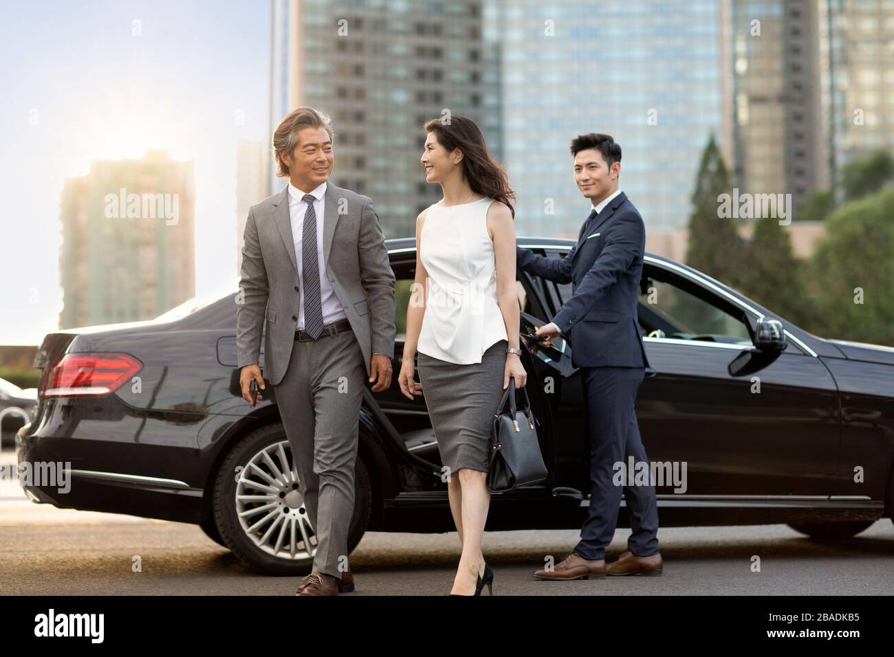 Confident Chinese business people getting out of car Stock Photo - Alamy