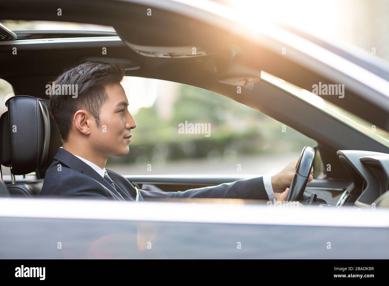 Confident businessman driving car Stock Photo - Alamy