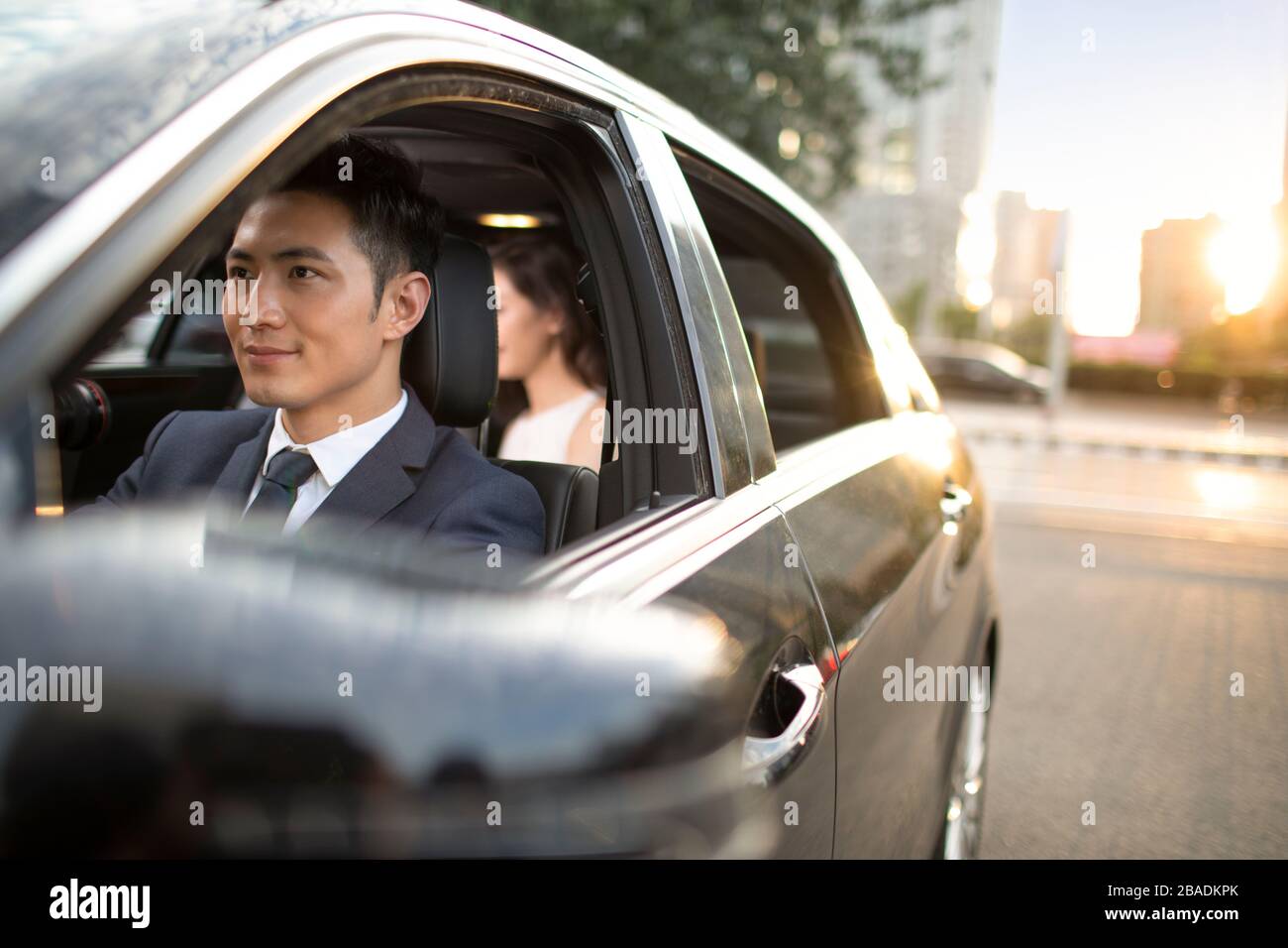 Young Chinese chauffeur driving car Stock Photo - Alamy
