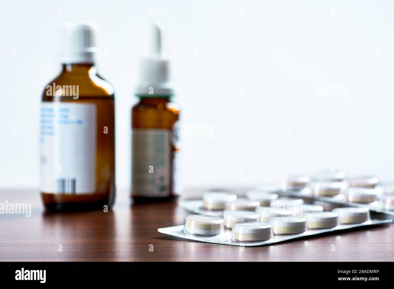 Closeup photo of blister pack with tablets, vials or drops on brown ...