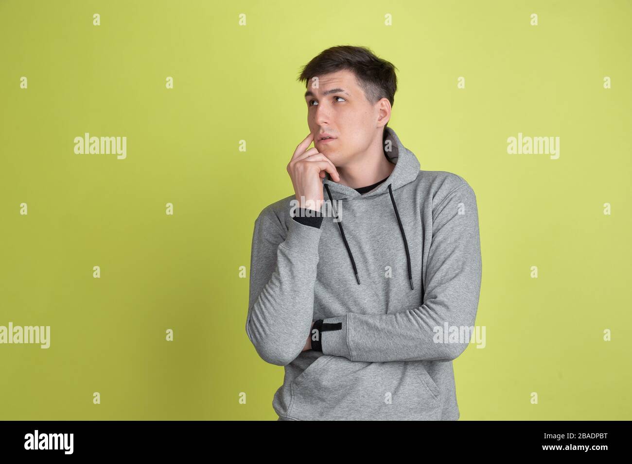 Thinking, dreamful. Caucasian man's portrait isolated on yellow studio ...
