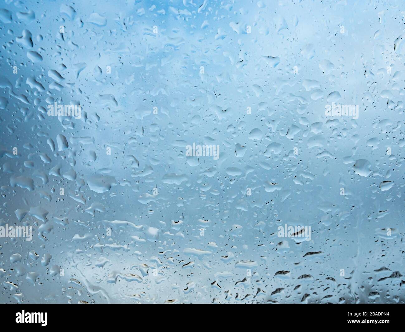 Wet window with rain drops and a cloudy sky outside background Stock ...