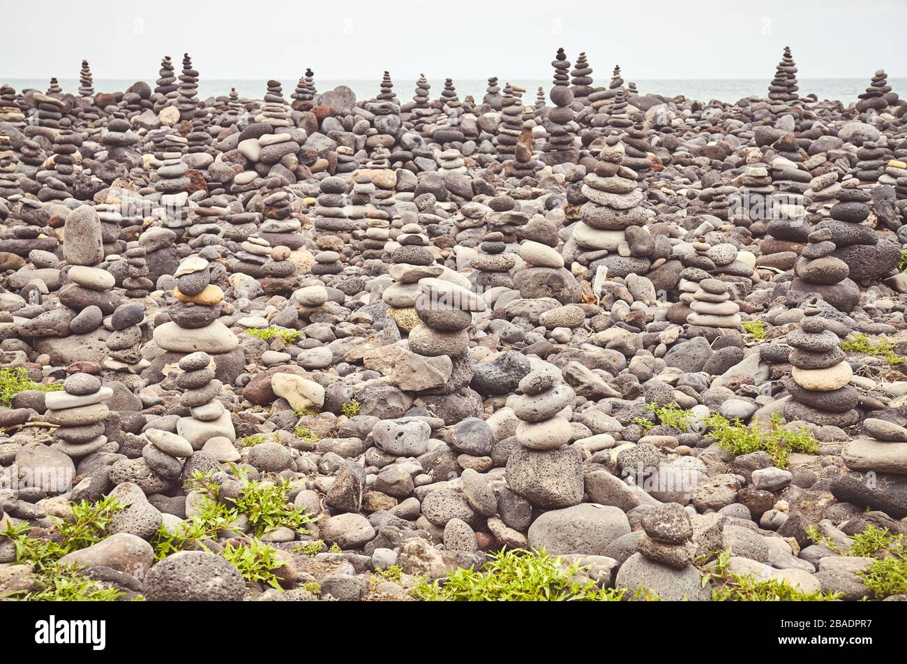 Stone stacks on a beach, color toning applied Stock Photo - Alamy