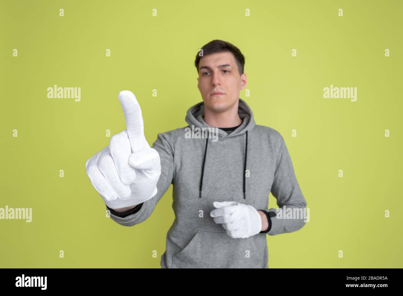 Showing stop sign. Caucasian man's portrait isolated on yellow studio ...