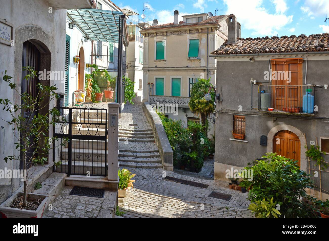 A narrow street between the houses of Morcone, a medieval village in ...