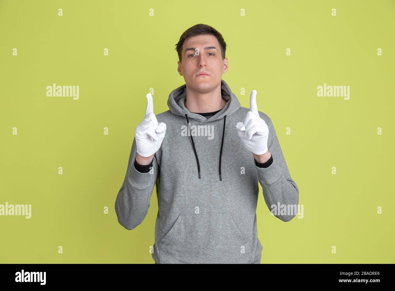 Choosing, pointing up. Caucasian man's portrait isolated on yellow ...