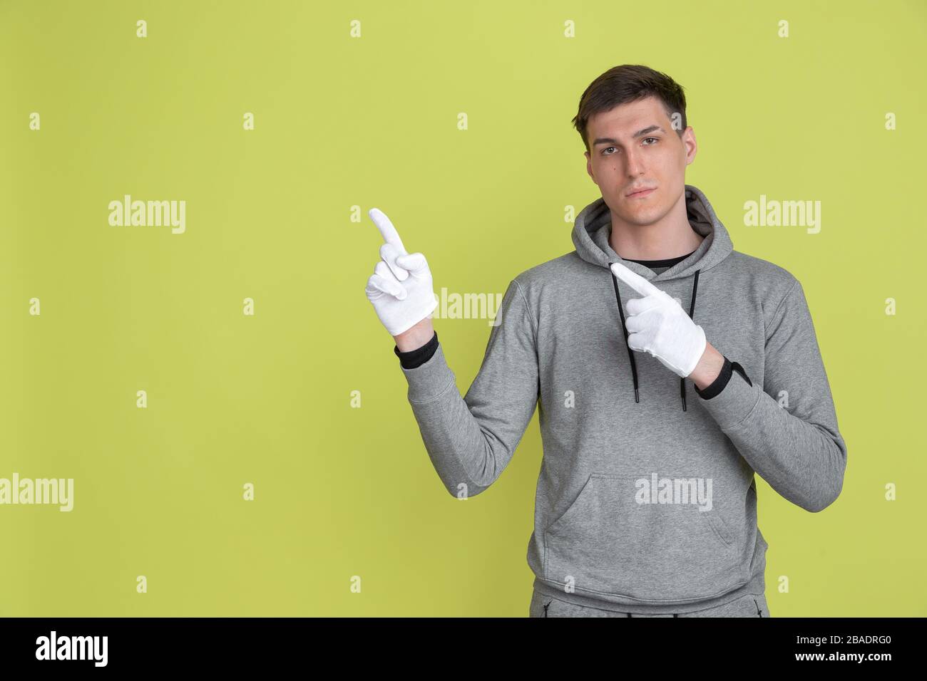 Choosing, pointing at side. Caucasian man's portrait isolated on yellow ...