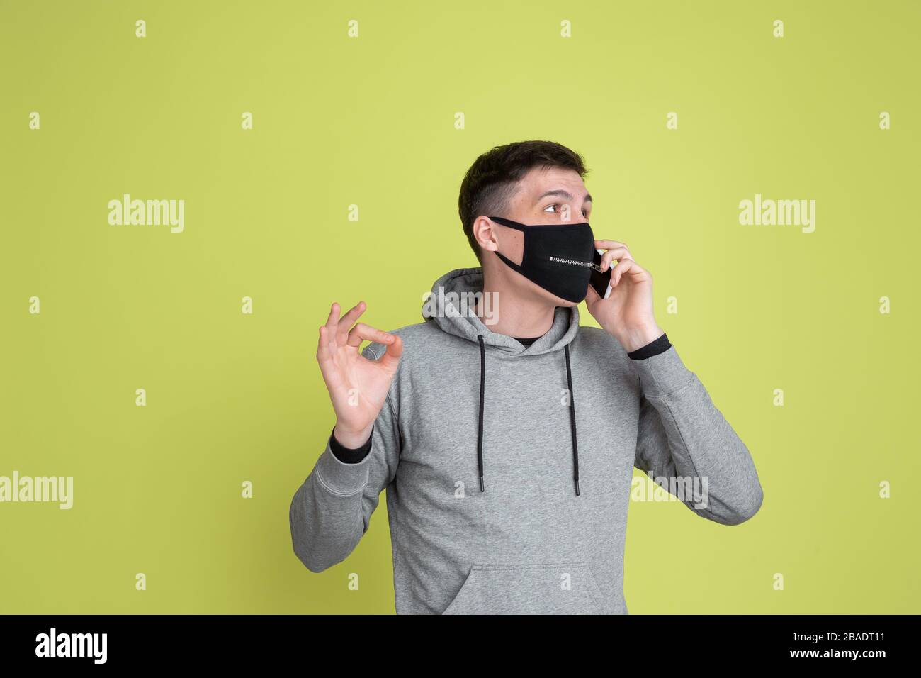 Talking on phone. Caucasian man's portrait isolated on yellow studio ...