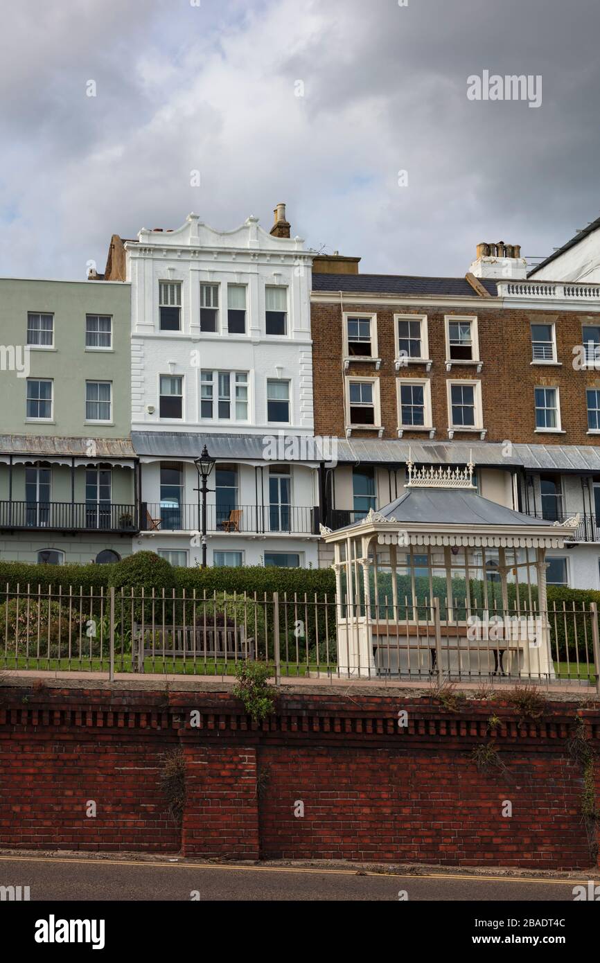 An iron Victorian seaside shelter sits in front of the terrace houses ...