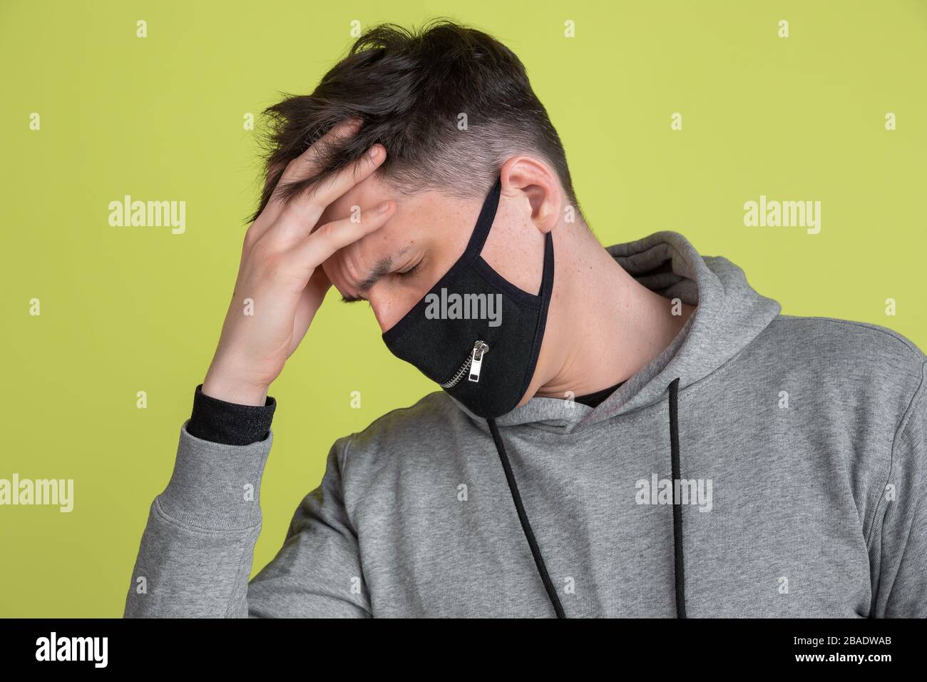 Hard thoughtful. Caucasian man's portrait isolated on yellow studio ...