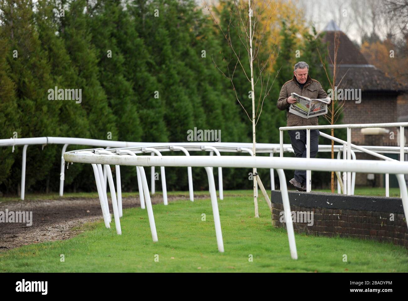 A racegoer reads the Racing Post as he checks the form at Lingfield ...