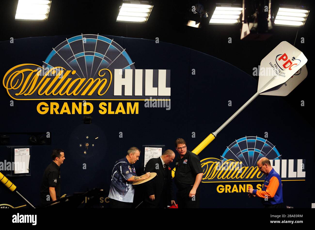 Phil Taylor signs the back of the dartboard after his victory over Co ...