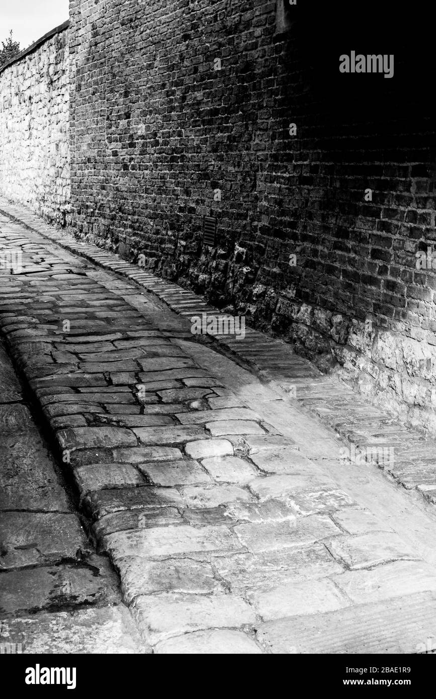 Walking down old cobbled alley Stock Photo - Alamy