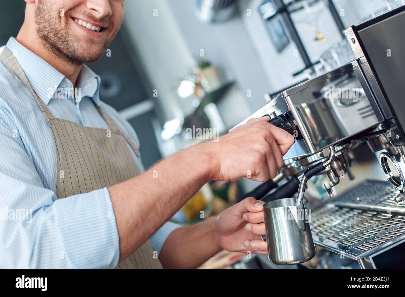 Coffee Passion. Young barista at coffee shop holding pitcher steaming ...