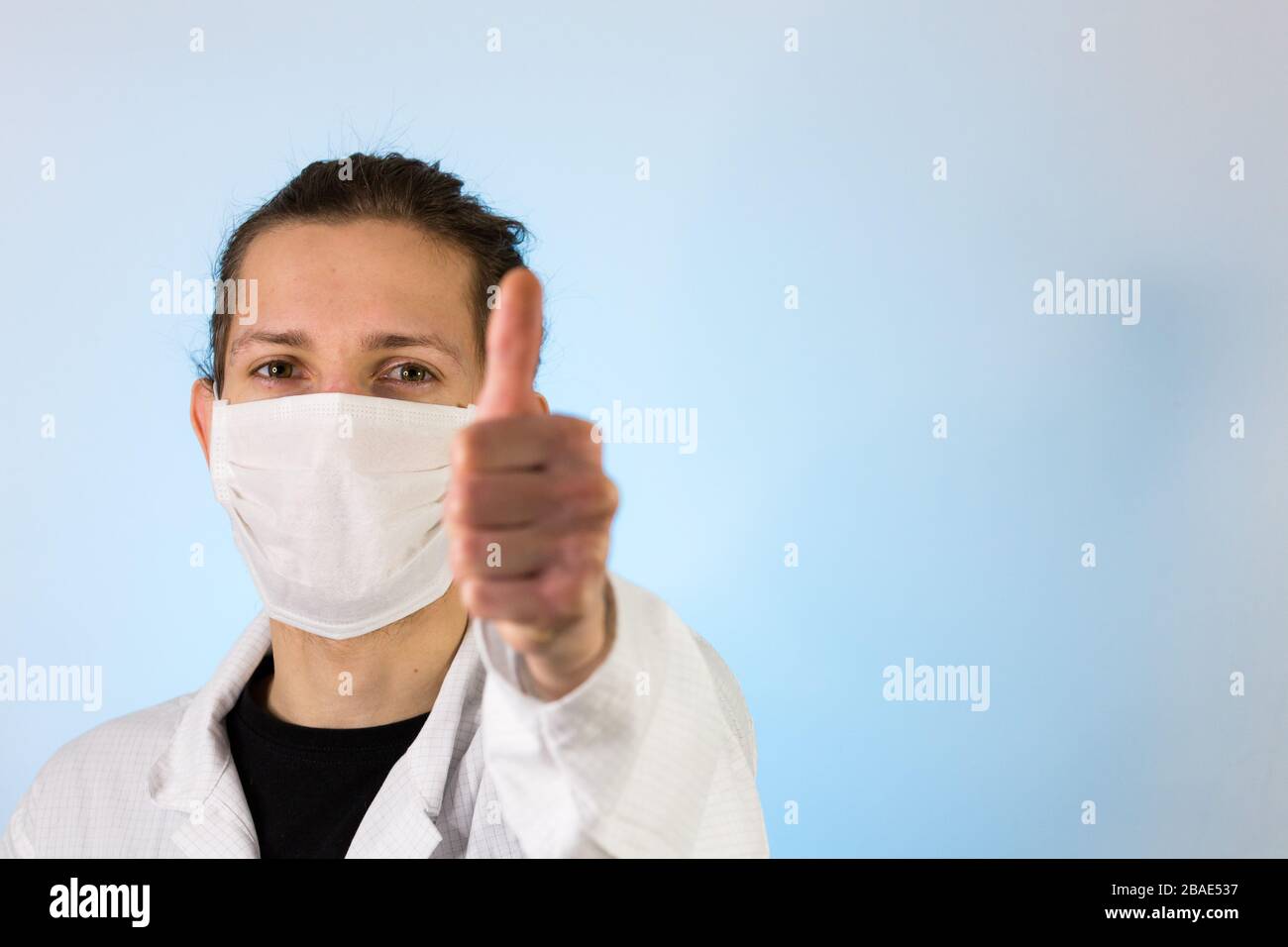 An adult male dressed in a white lab coat with a protective face mask ...