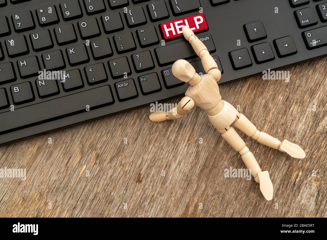 Online HELP button. Wooden dummy pressing HELP button on a computer ...