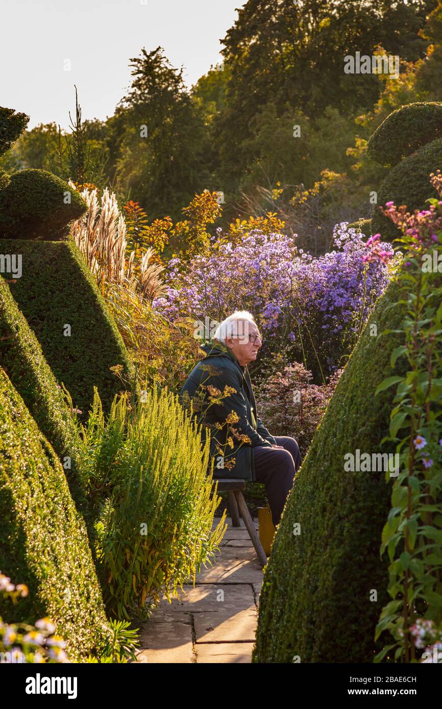 An elderly man sits in the sun amid the Colourul Autumn Views of ...
