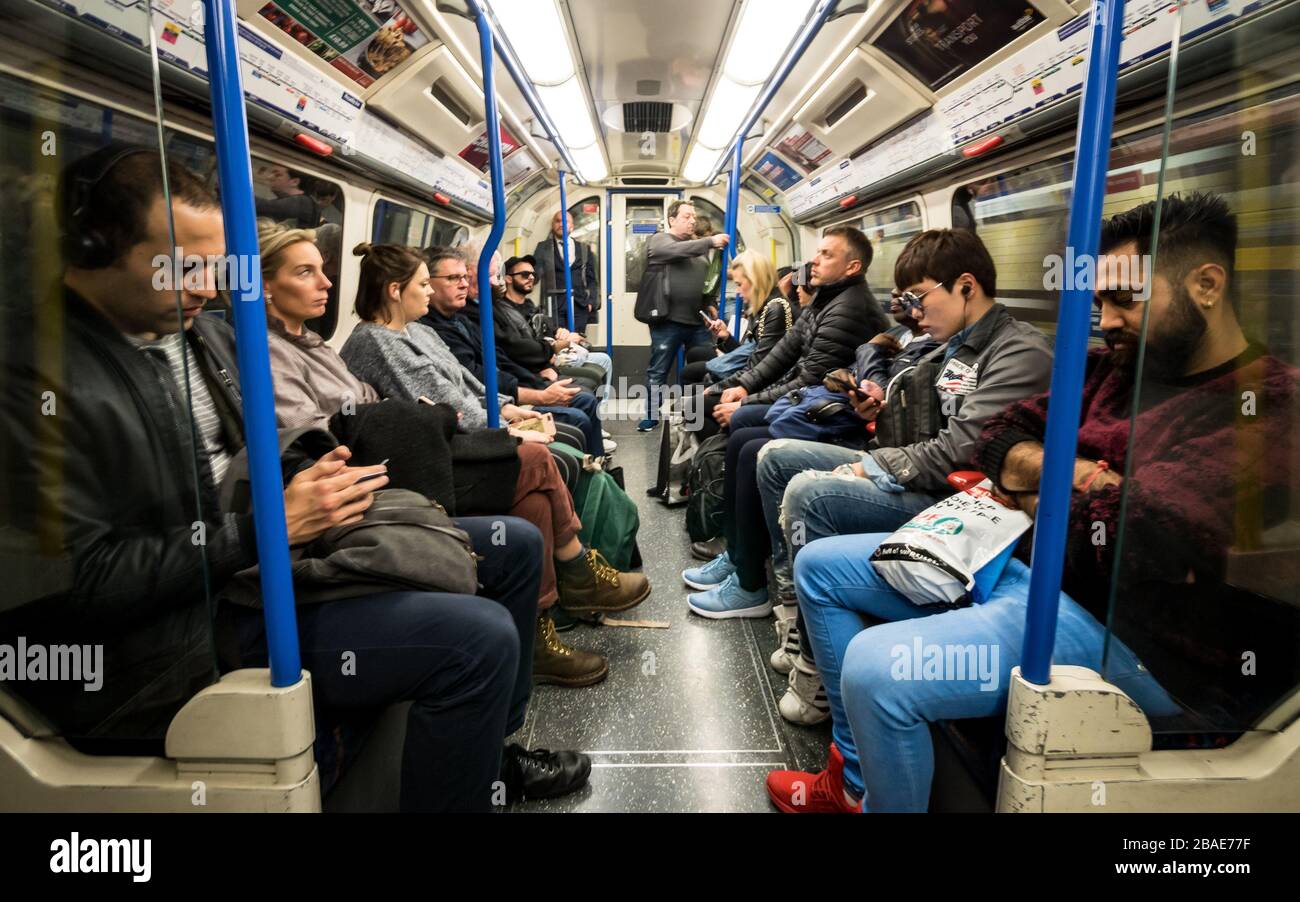London Underground tube train passengers. An interior view of a busy ...